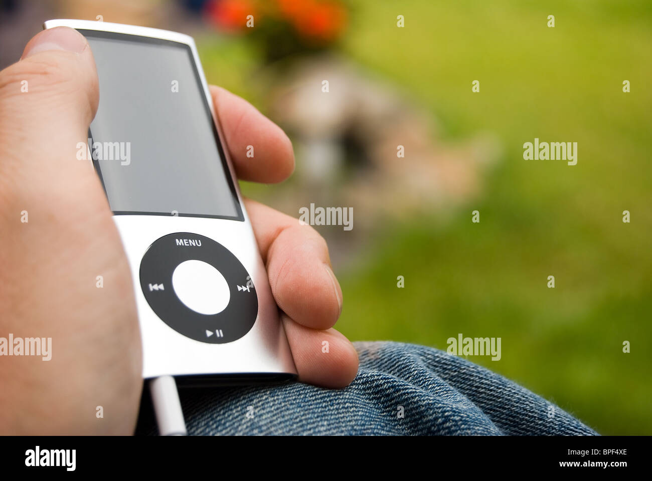 Listening to an Ipod in the garden Stock Photo - Alamy