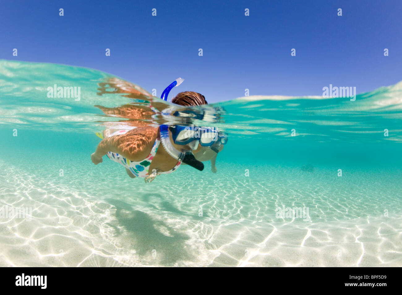 couple enjoying snorkeling the clear tropical waters of a remote island ...