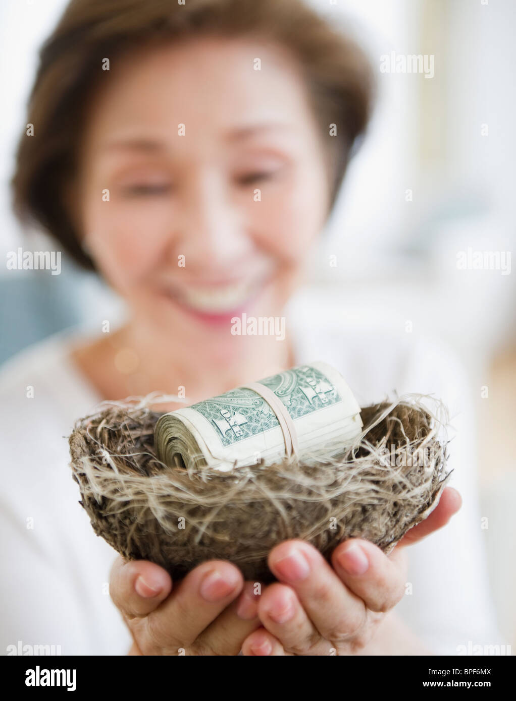 Japanese woman holding nest filled with money Stock Photo - Alamy