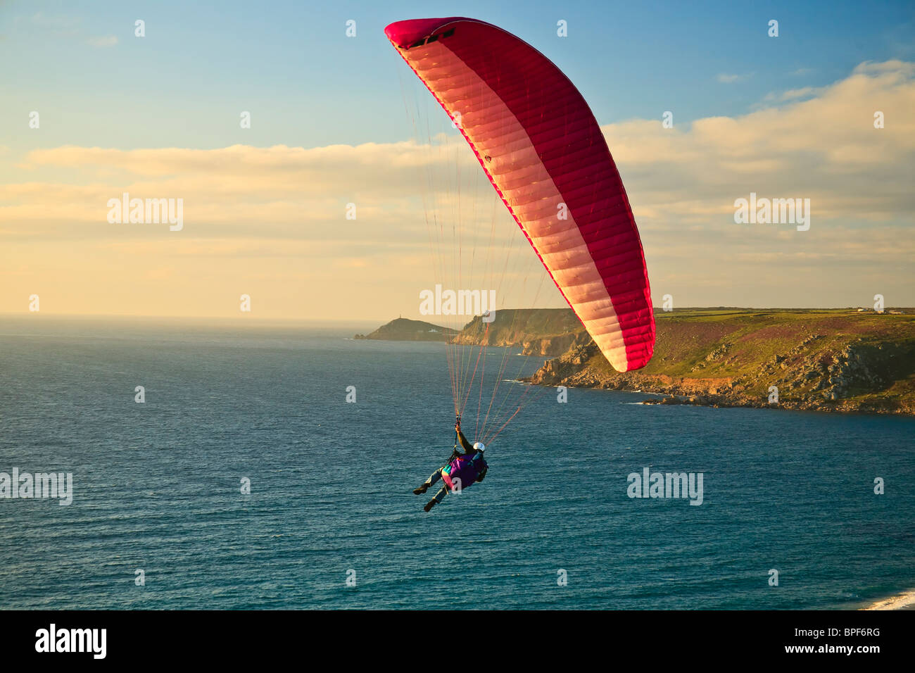A bright red paraglider over the Cornish cliffs Stock Photo - Alamy