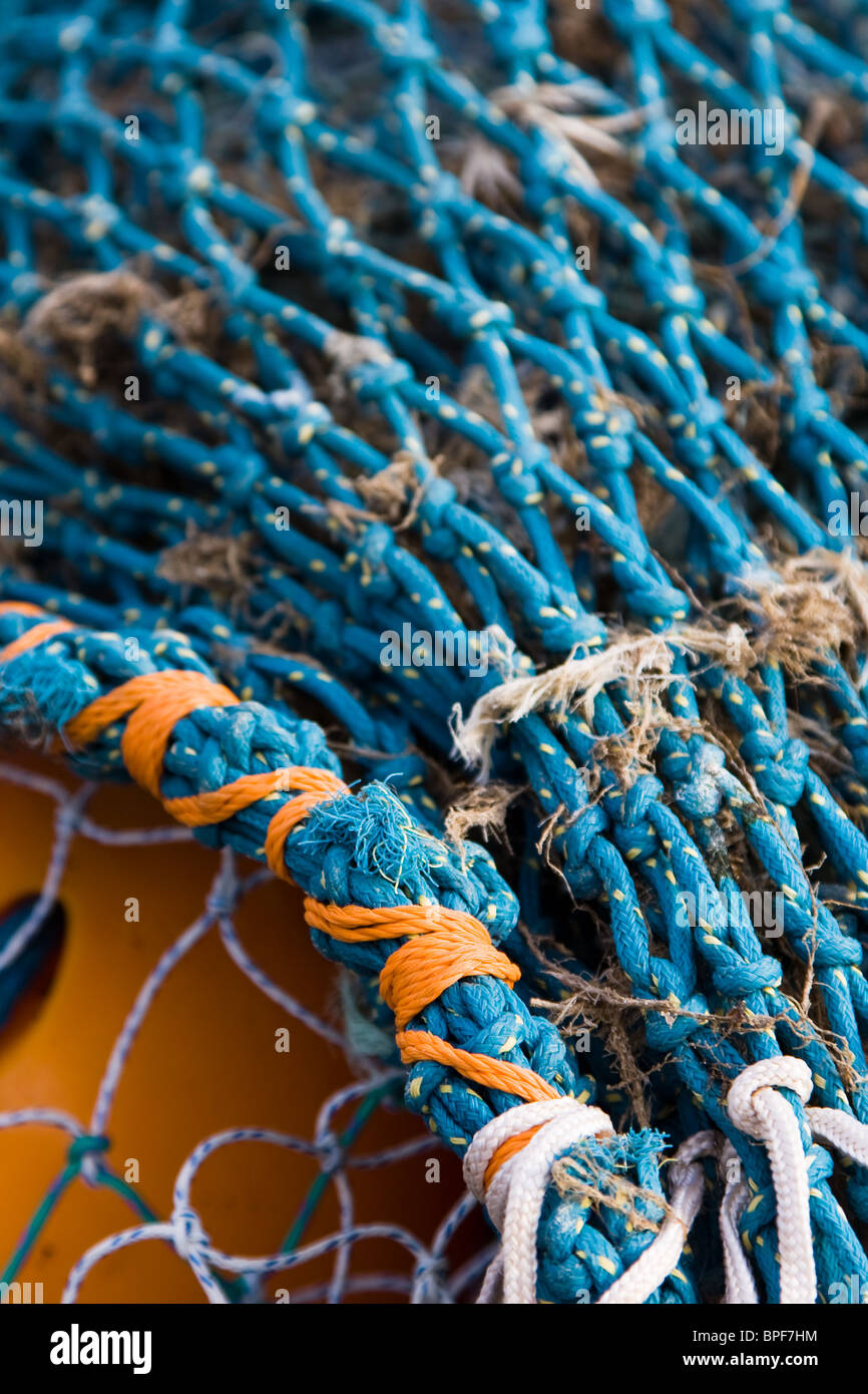 Blue fishing net covering an orange buoy Stock Photo - Alamy