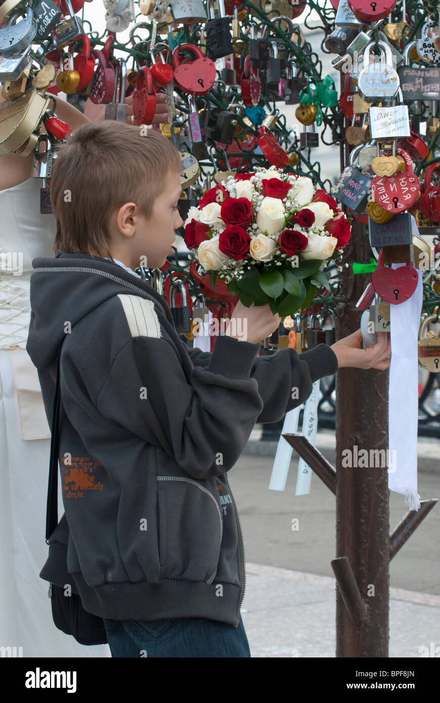 A little boy touching a lock on the love tree Stock Photo - Alamy
