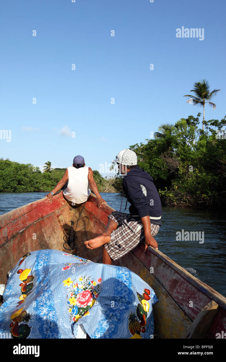 Kuna indigenous boys sitting on prow of a traditional dugout wooden ...