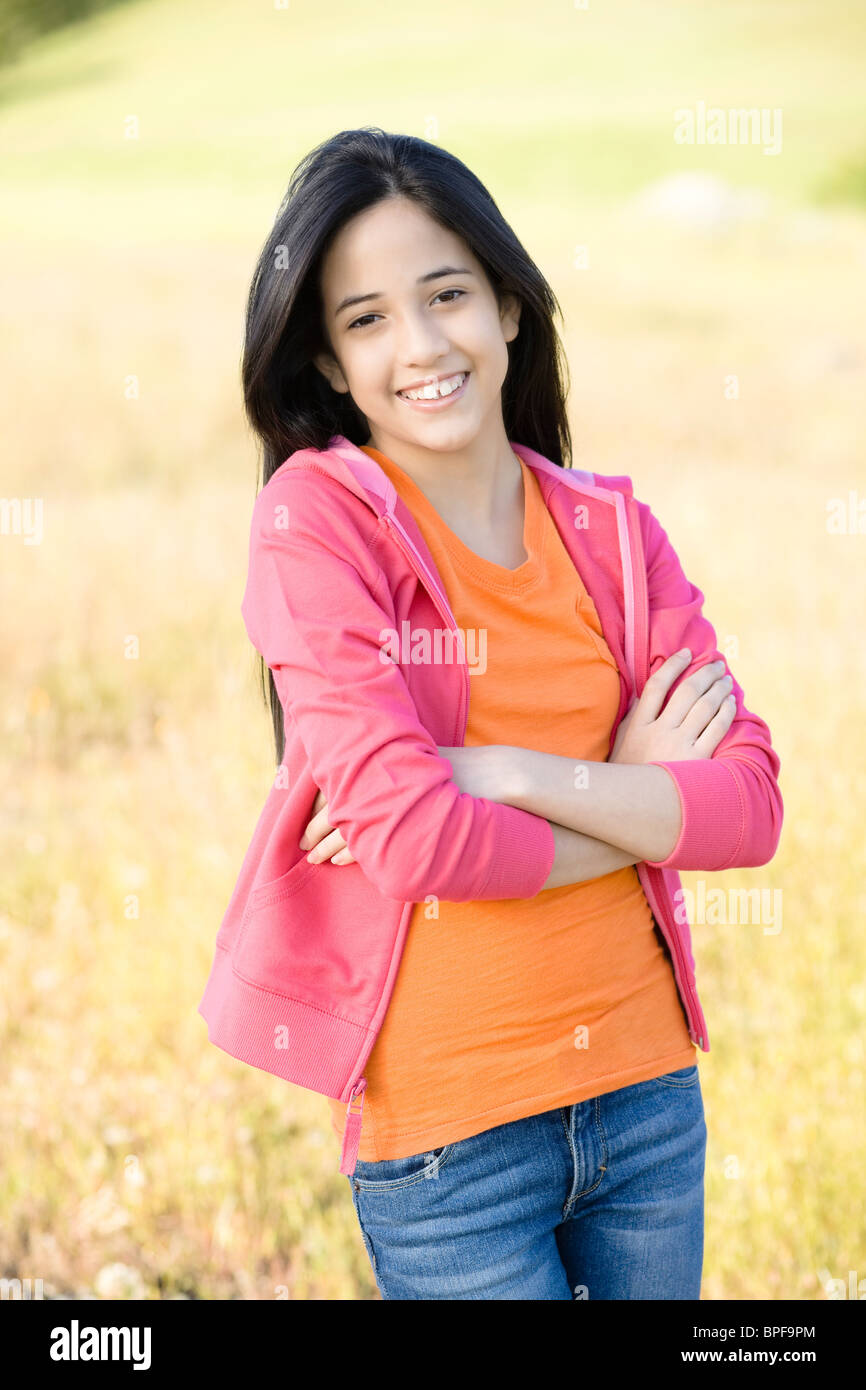 Hispanic girl in field with arms crossed Stock Photo - Alamy