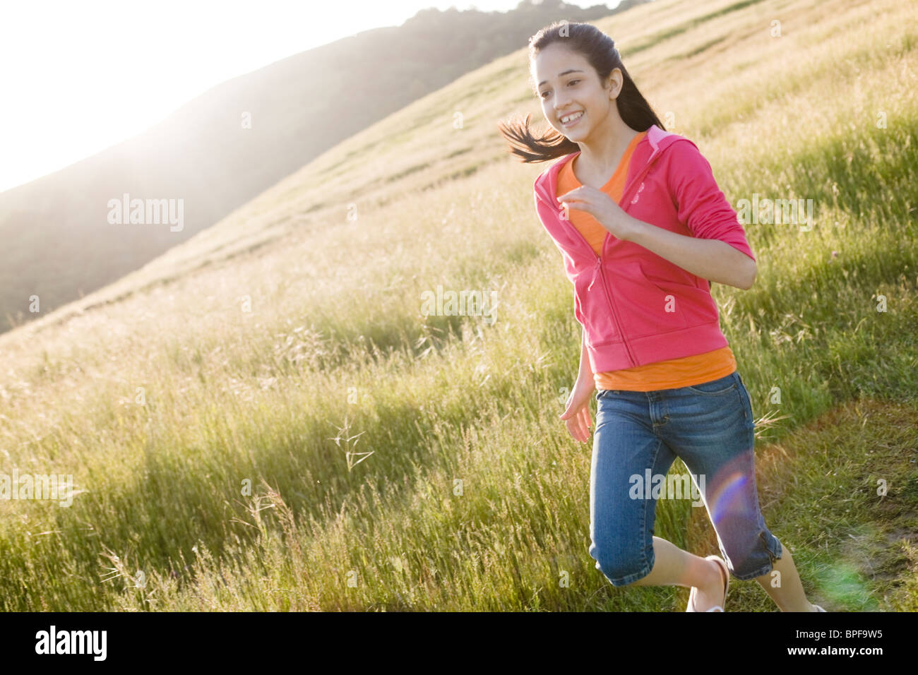 Hispanic girl running in field Stock Photo - Alamy