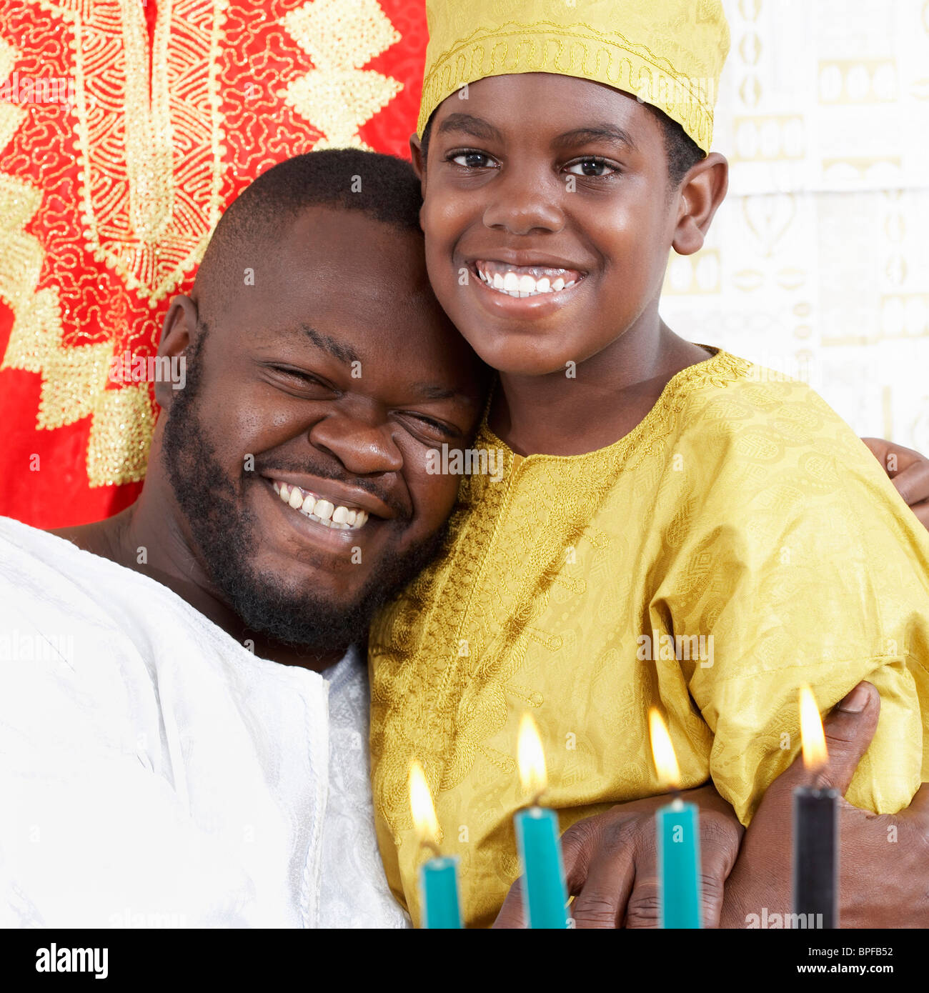 African American father hugging son in traditional clothing Stock Photo ...