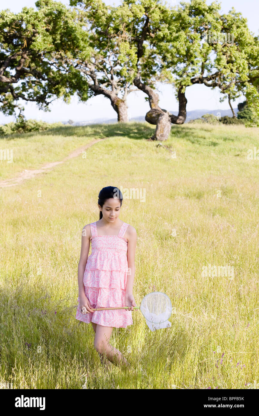 Hispanic girl in field holding net Stock Photo - Alamy