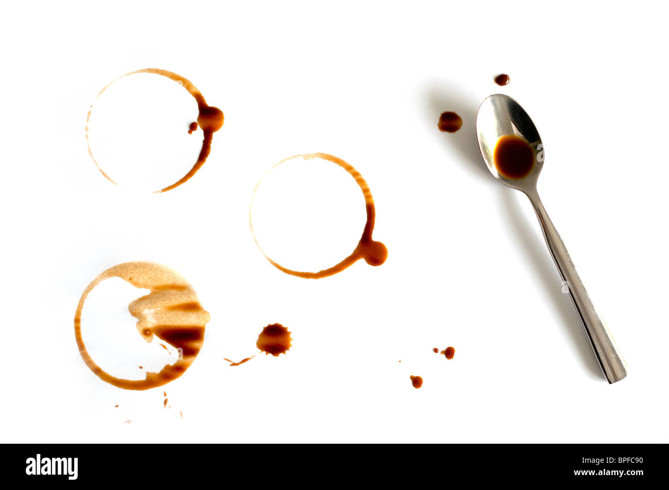 Coffee stains and a spoon which has been used to stir coffee isolated ...