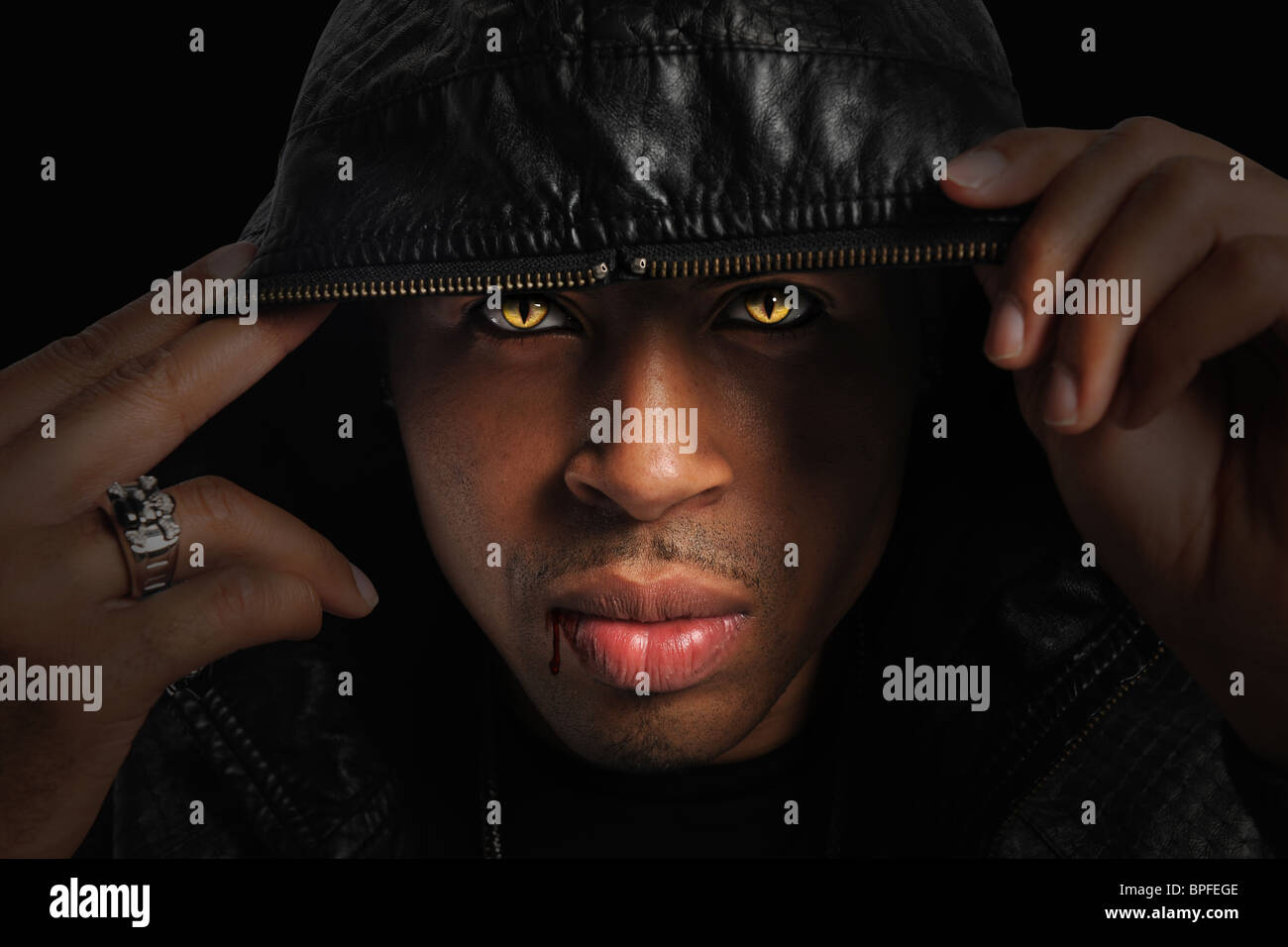 Portrait of African American vampire with hood over head with strong ...