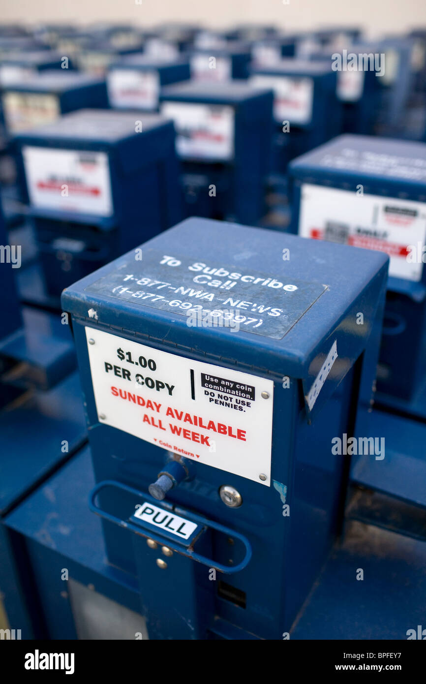 Rows of surplus newspaper boxes sit in an alley behind a building in ...
