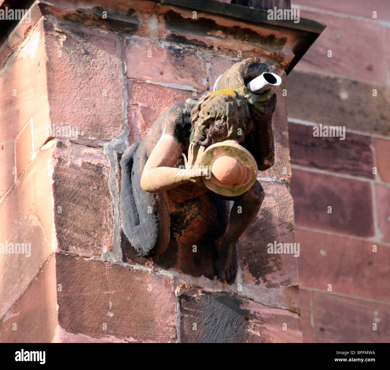 Gargoyle in the form of a man holding a barrel or jug, on Freiburg ...
