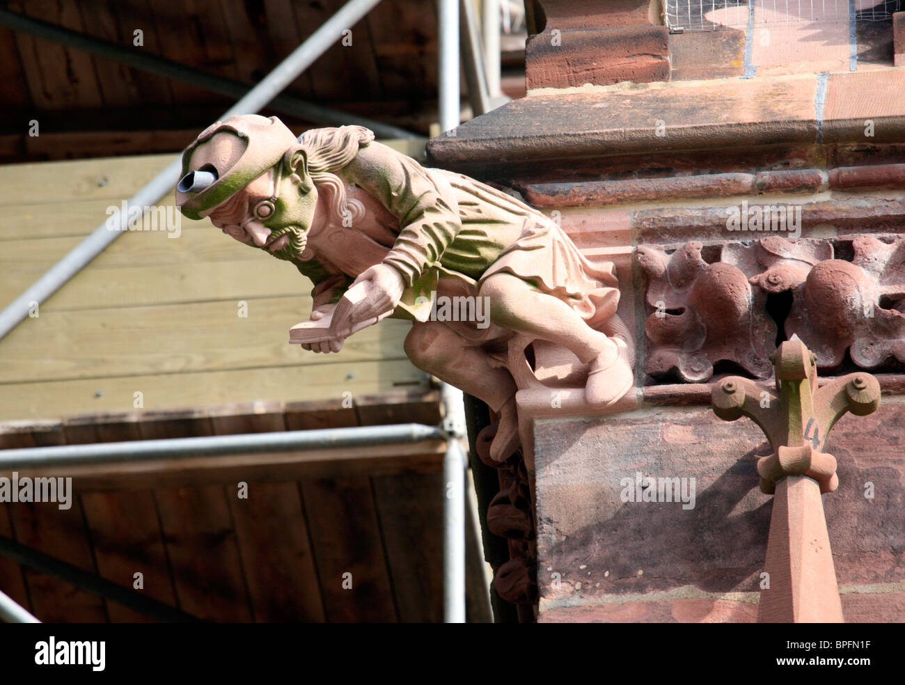 Gargoyle in the form of a seated man reading a book, on Freiburg ...