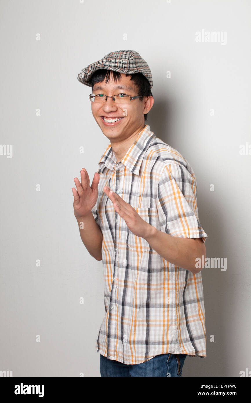 Cheerful young man clapping hands, wearing a plaid shirt and checkered ...