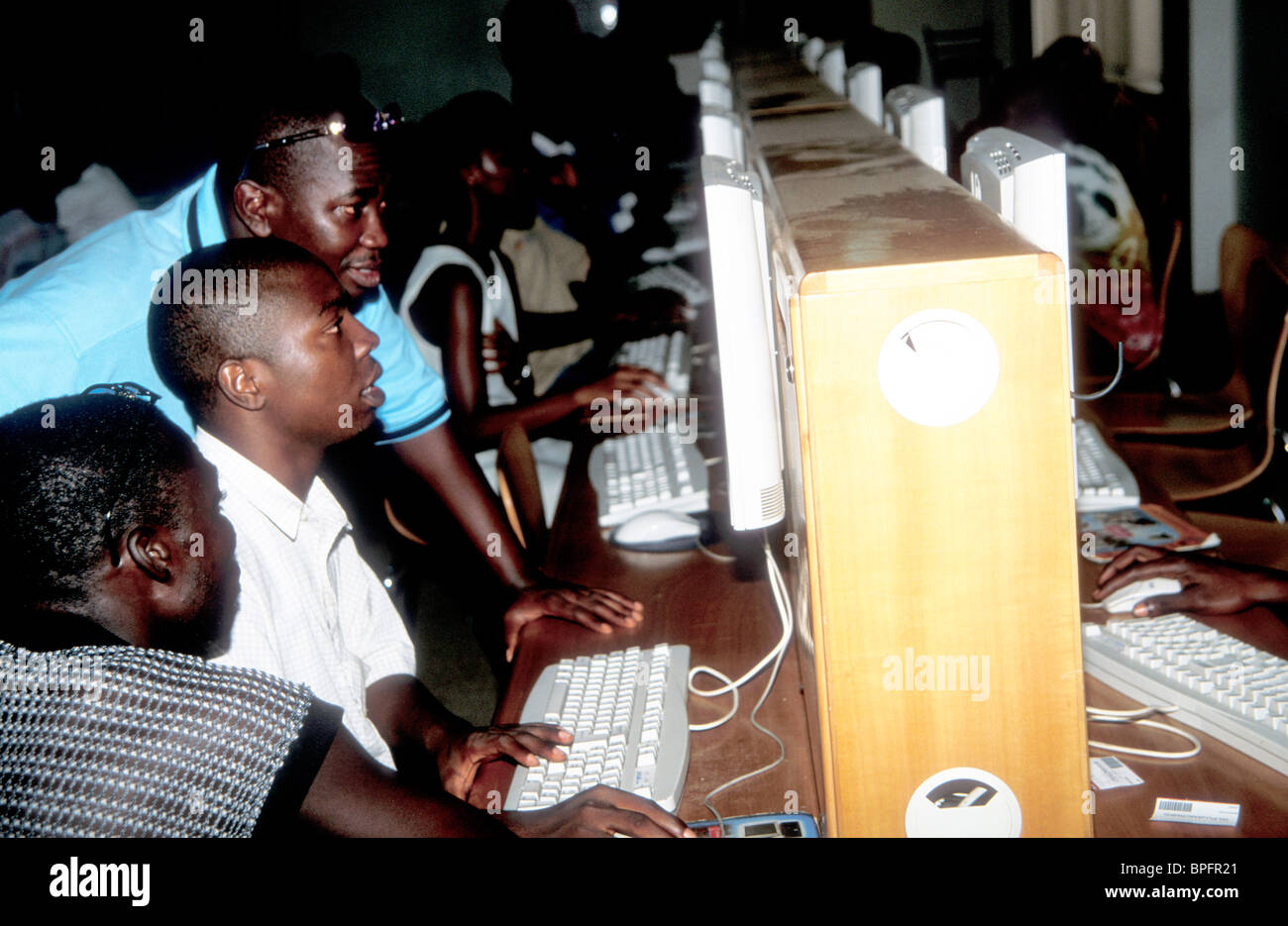 Three men look at a computer screen in a big cyber-cafe in Accra ...