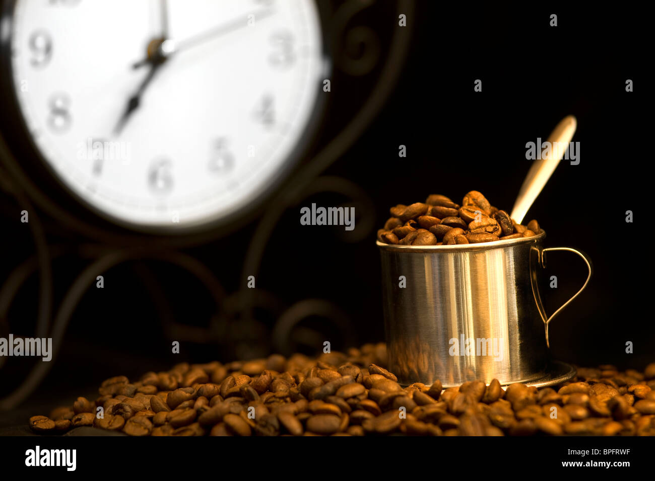 steel cup of coffee and clock at background Stock Photo - Alamy