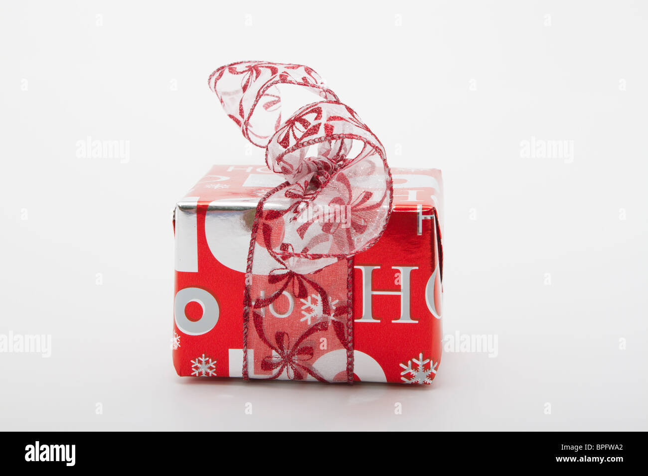 A pretty wrapped Christmas present in red and silver with fancy ribbon ...