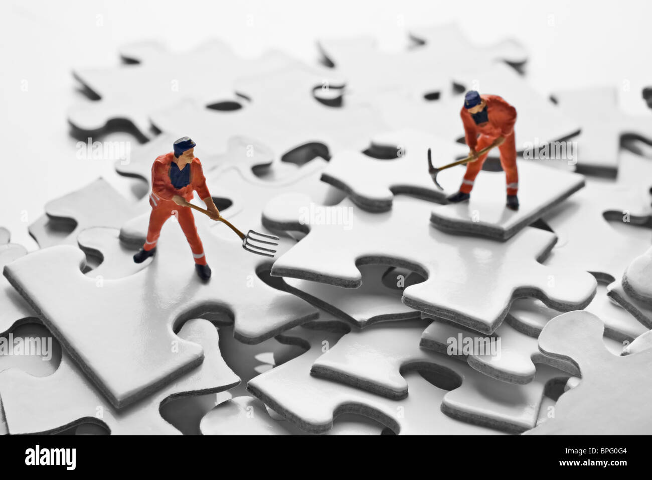 Worker figurine on puzzle pieces Stock Photo - Alamy