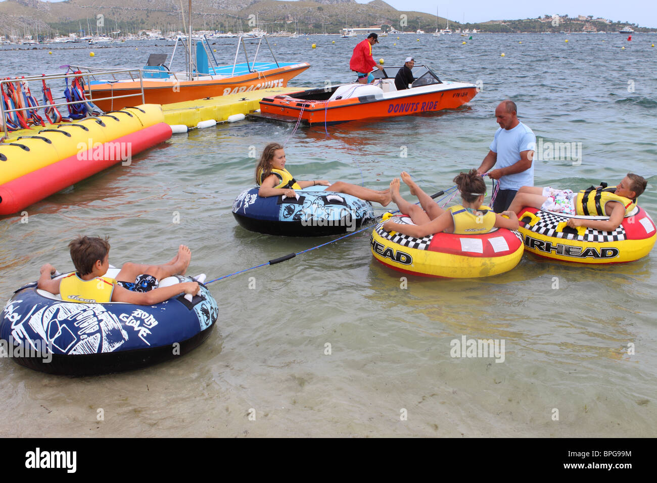 Mallorca Majorca teenage children on Donut Ringo inflatable water ride ...