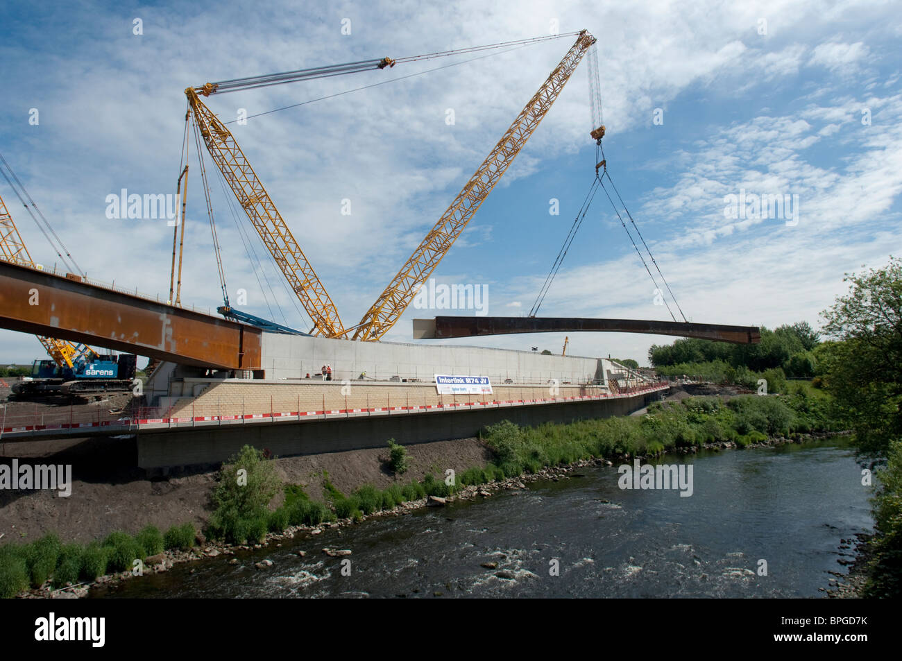 Construction workers move a steel bridge into position over the River ...