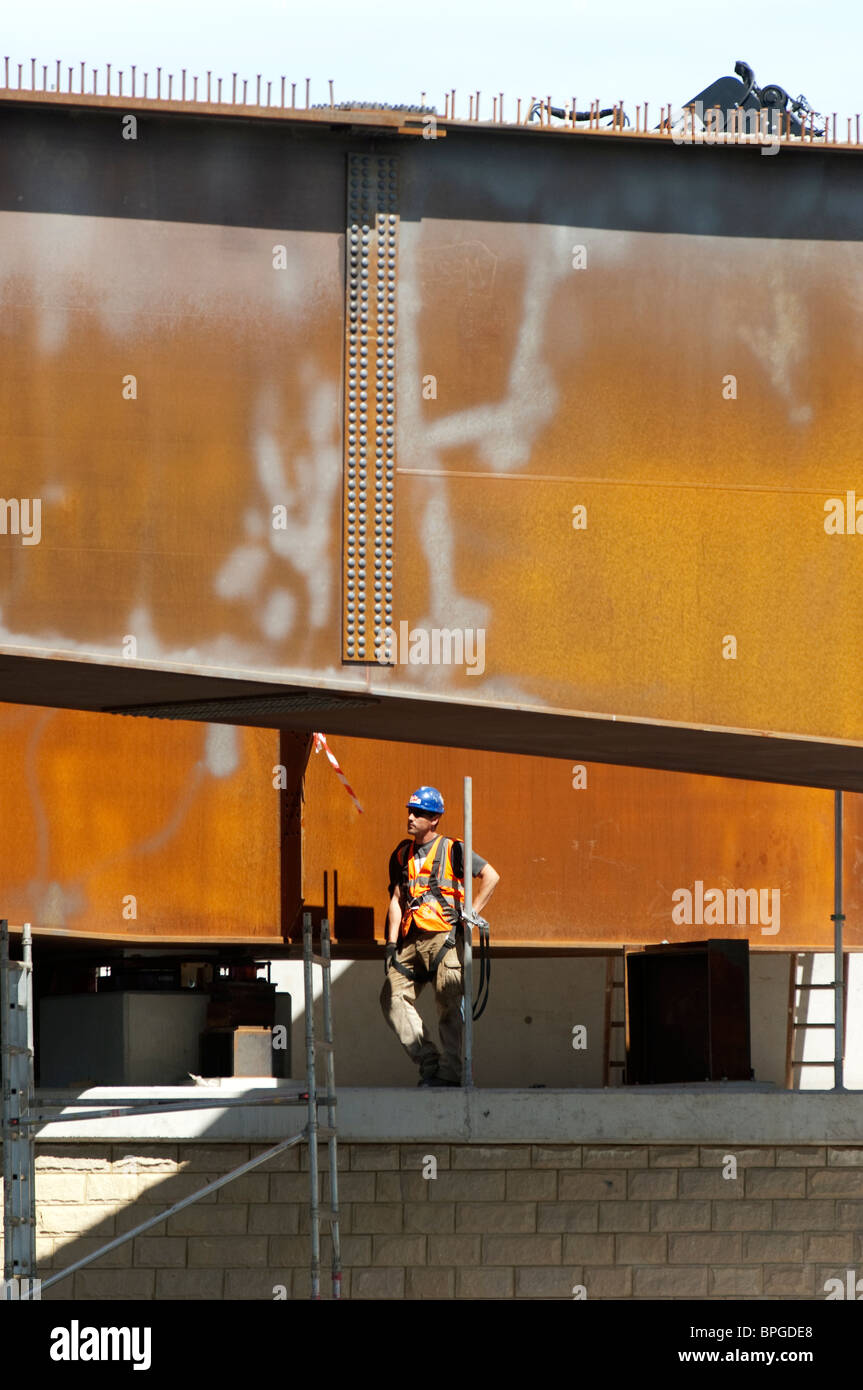A construction worker stands next to a steel bridge prior to ...