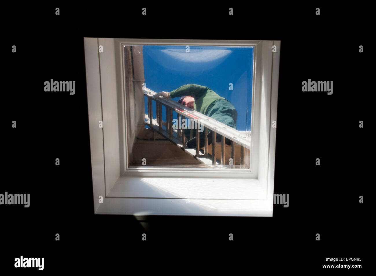 Man up ladder looking through window High Resolution Stock Photography ...