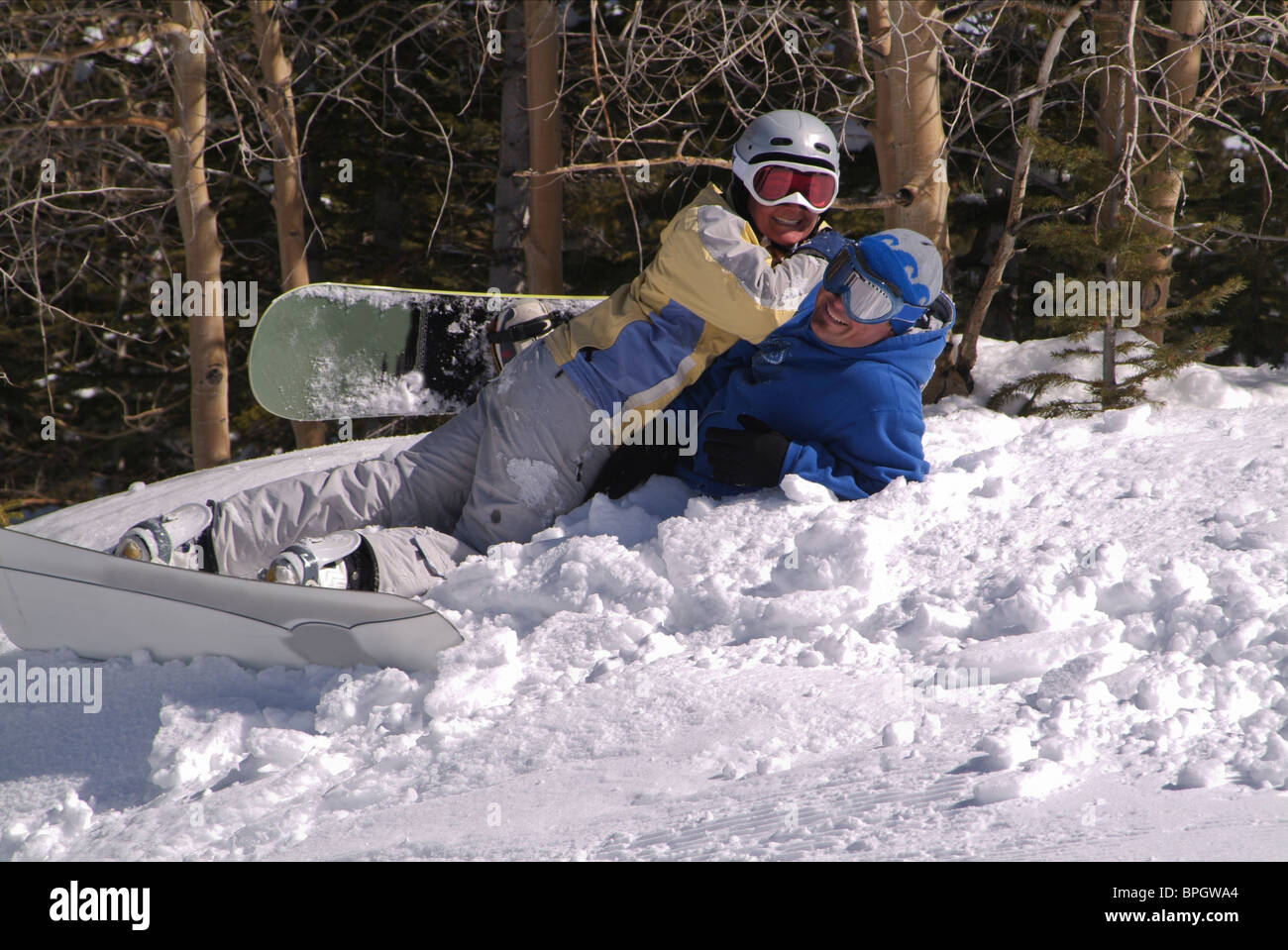 Snowboarders laying in snow laughing Stock Photo - Alamy
