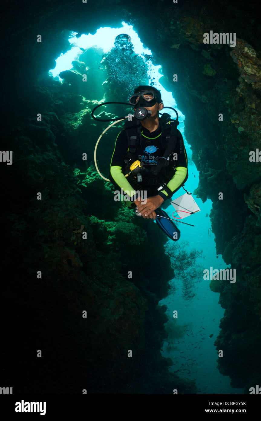 Diver exploring a narrow cavern, Menjangan, Bali, Indonesia Stock Photo ...