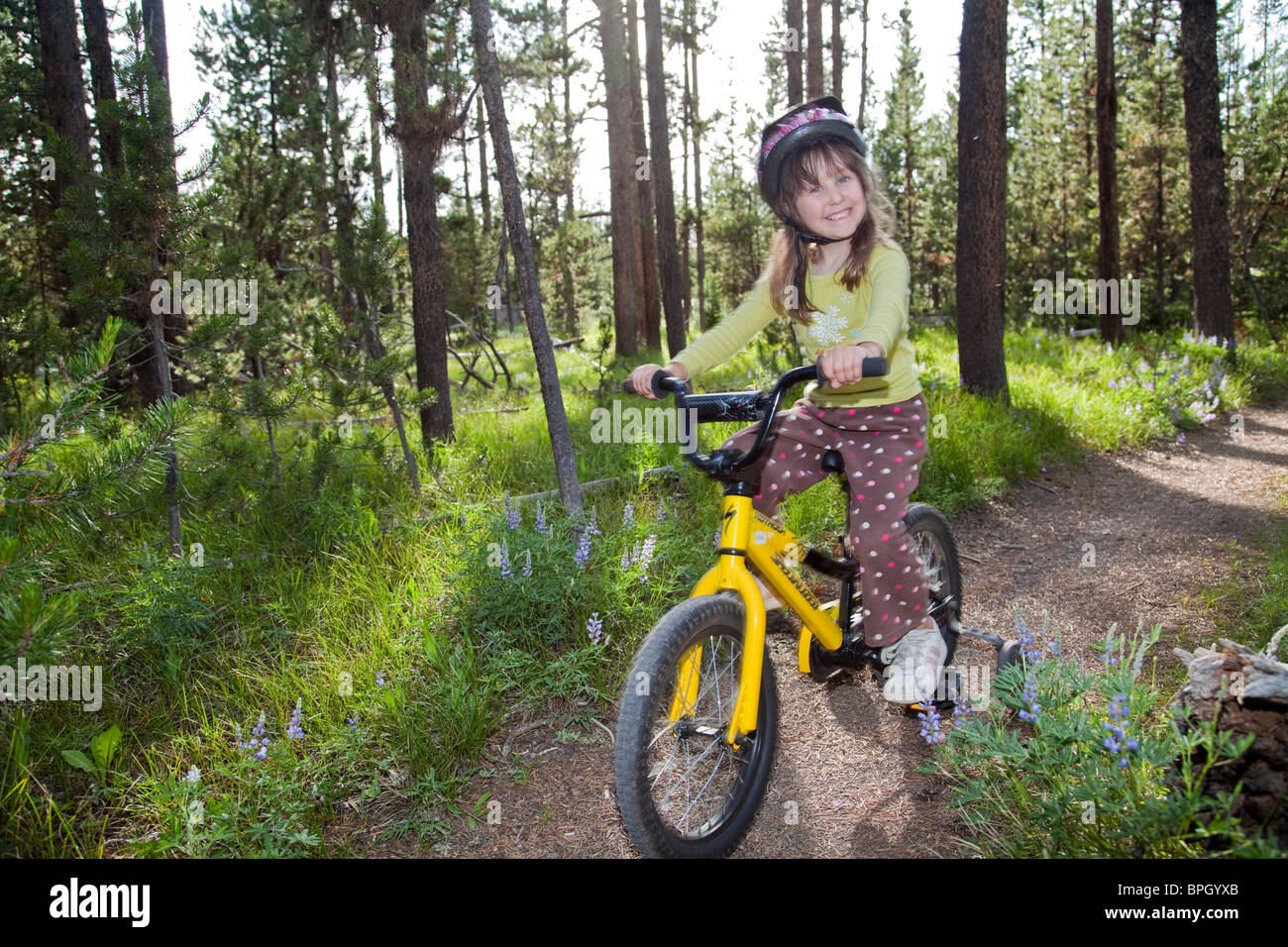 Girl riding bike through trees Stock Photo - Alamy