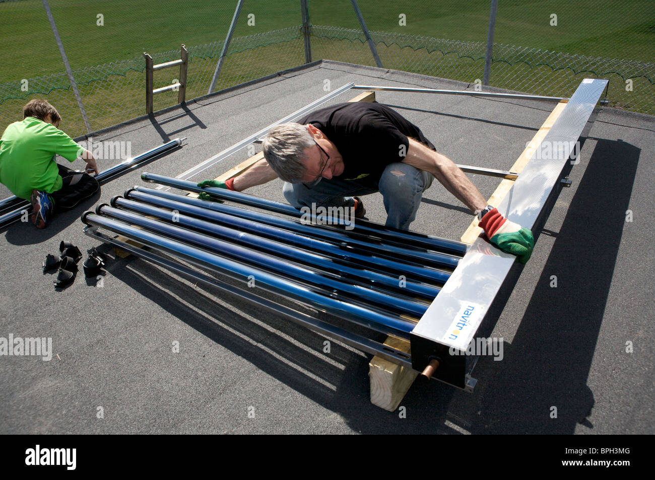 Man assembling solar panels on roof. Vacuum tubes to heat water Stock ...