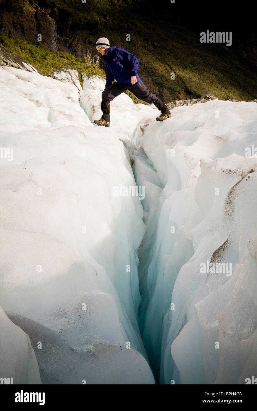 Man crosses a deep crevasse on a glacier Stock Photo - Alamy