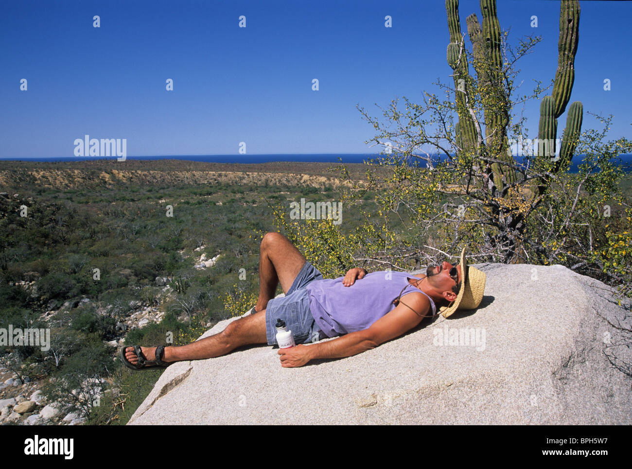 Man resting on rock Stock Photo - Alamy