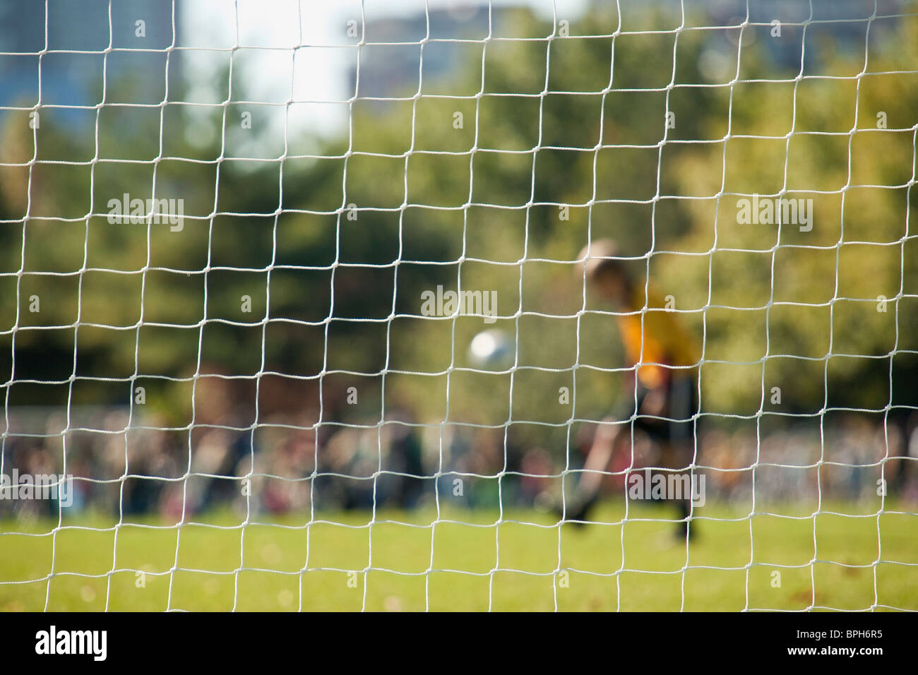 Soccer player viewed through goal net in a soccer field, Teddy Ebersol ...