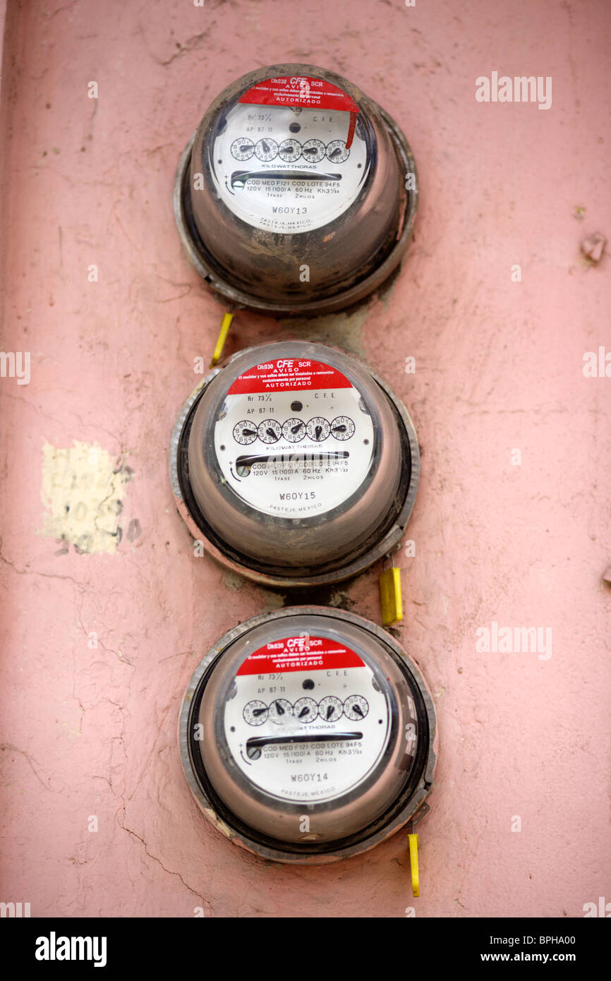 Three electricity meters on a wall Stock Photo - Alamy