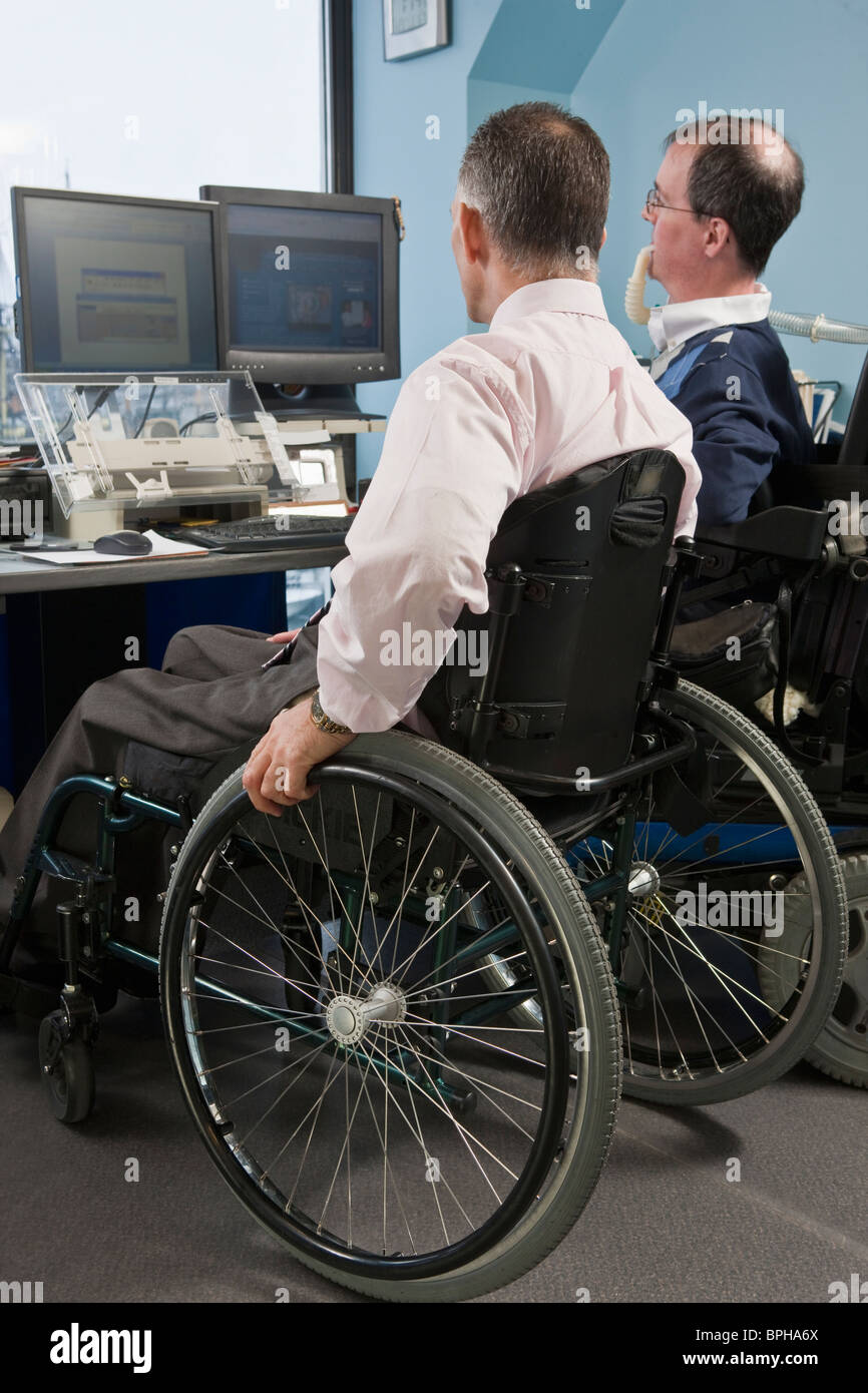 Two businessmen in a wheelchair working in an office Stock Photo - Alamy