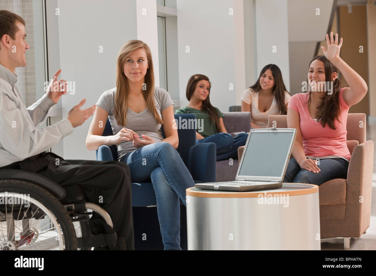 Teacher with spinal cord injury giving a lecture to students in ...