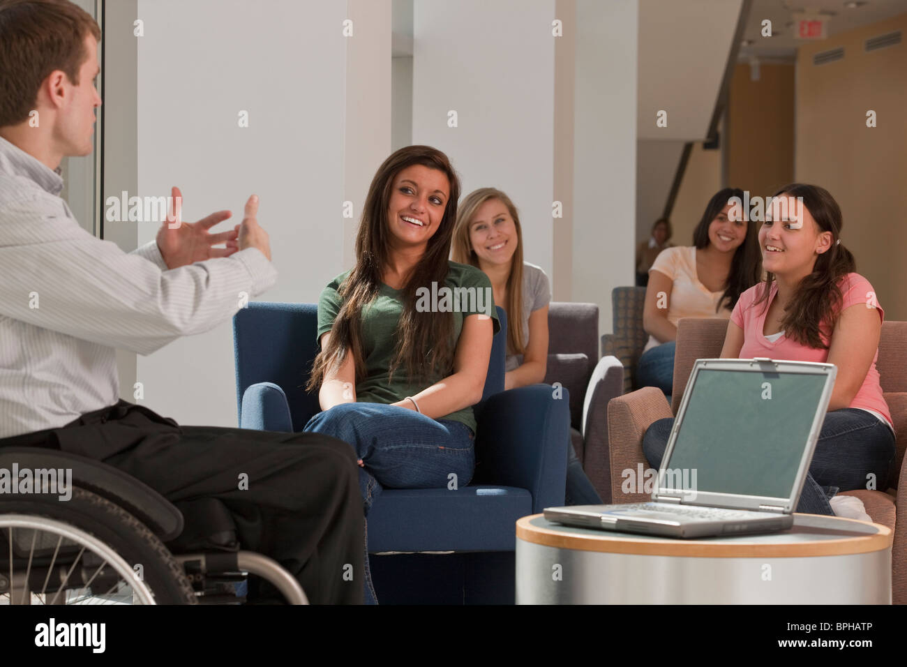 Teacher with spinal cord injury giving a lecture to students in ...