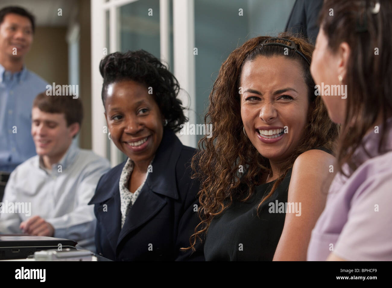 Visually impaired Hispanic businesswoman with her colleagues in a board ...