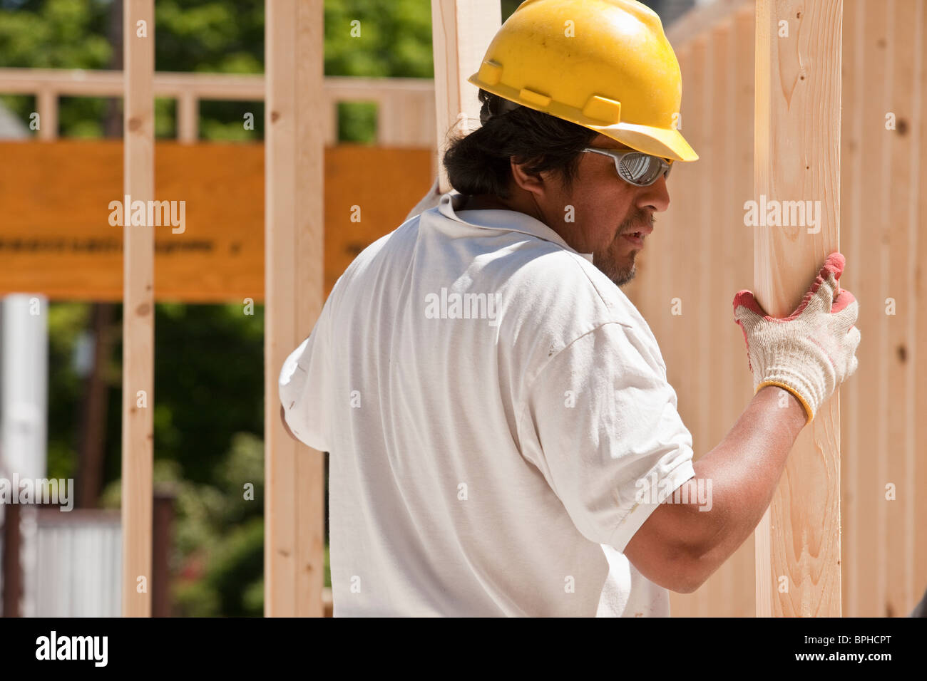 Carpenter lifting wooden frame at a construction site Stock Photo - Alamy