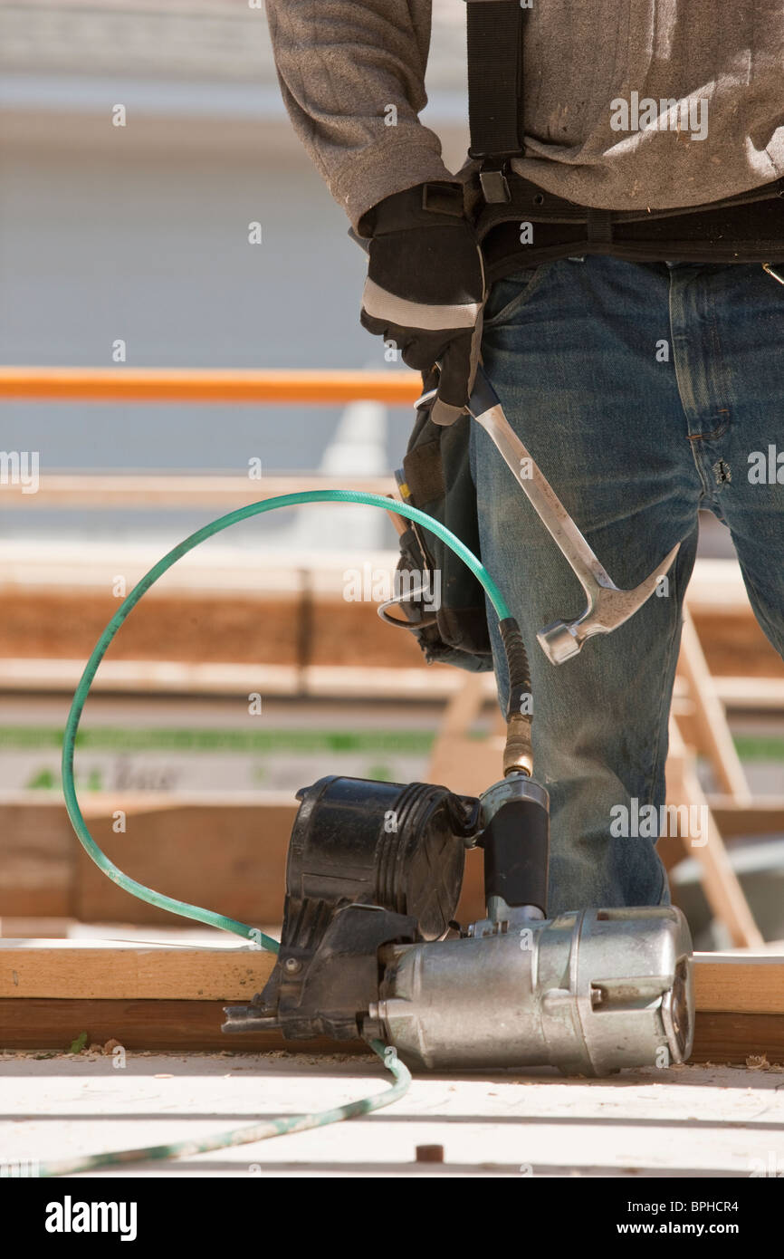 Carpenter and nail gun at a construction site Stock Photo - Alamy