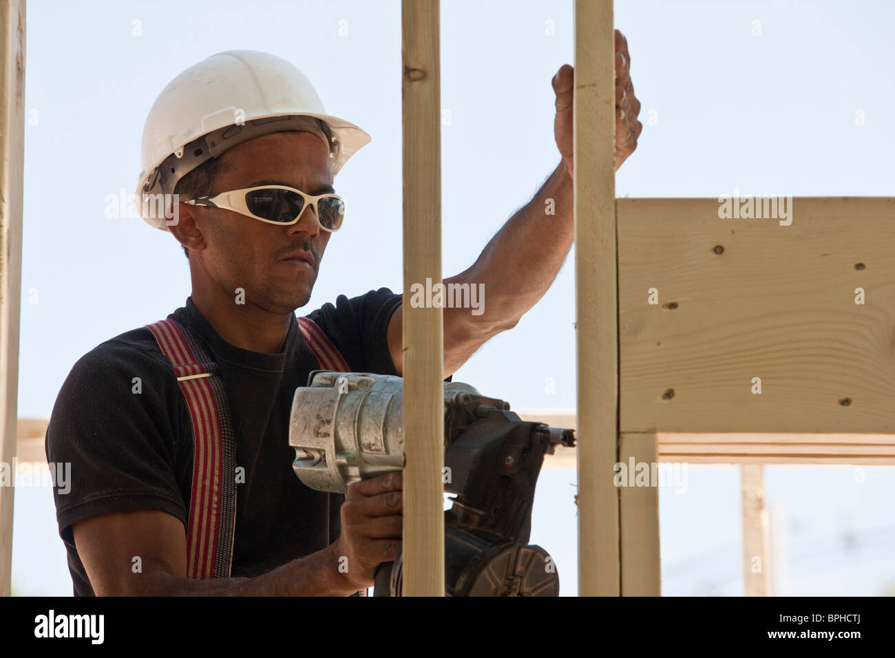 Carpenter using a nail gun at a construction site Stock Photo - Alamy