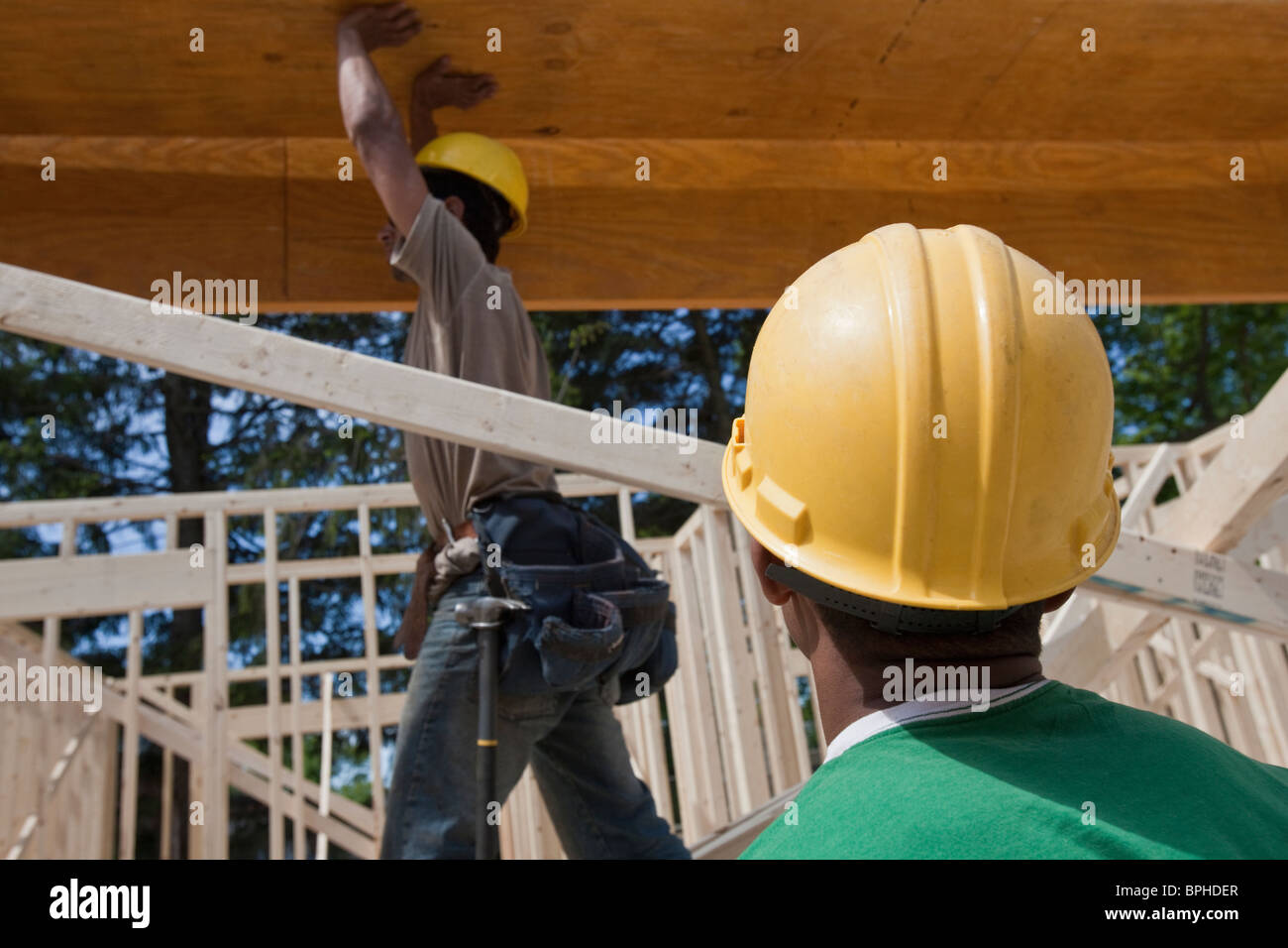 Carpenter lifting a laminated beam at a construction site Stock Photo ...