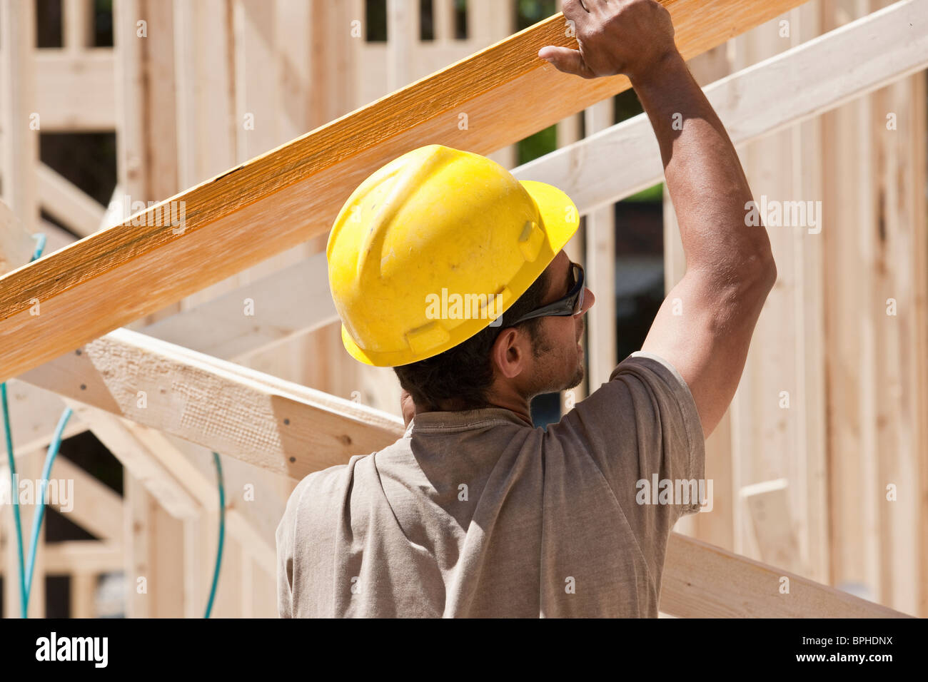 Carpenter lifting a laminated beam at a construction site Stock Photo ...