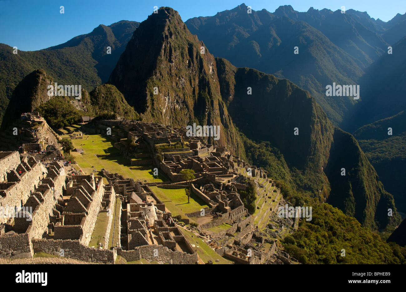 Tourists amidst the intricate stonework of ruined buildings and garden ...