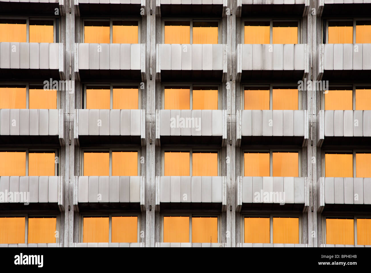 Symmetrical features of a building with yellow windows Stock Photo - Alamy