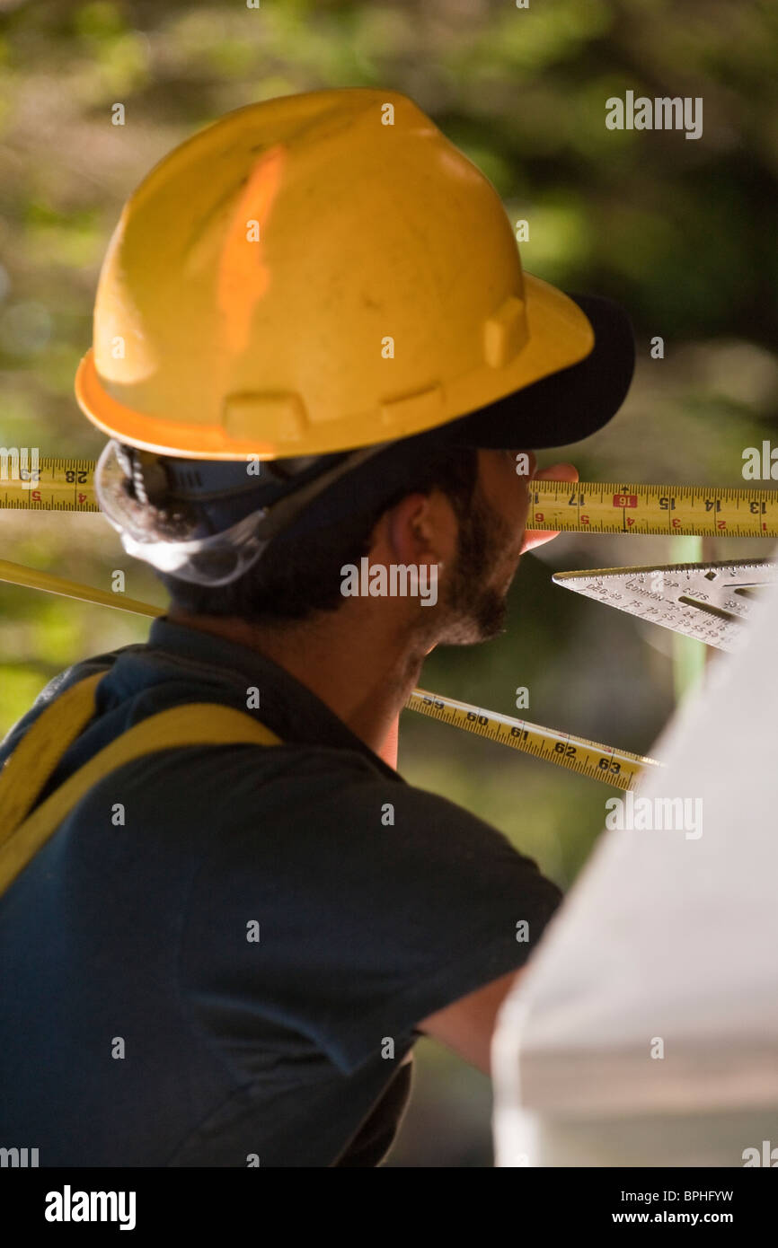 Carpenter using a tape measure at a construction site Stock Photo - Alamy