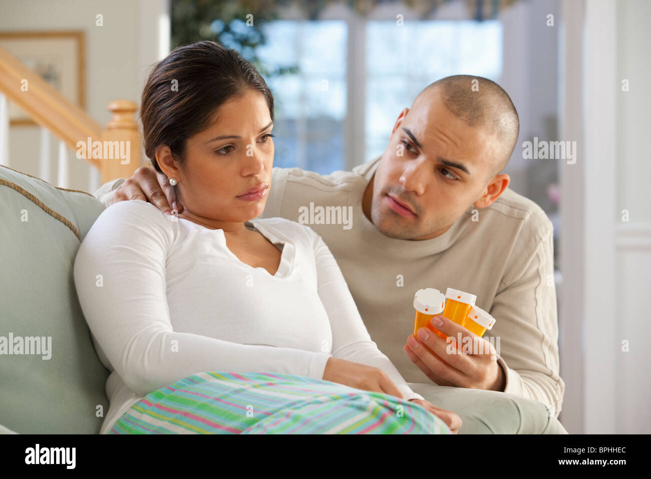 Hispanic man giving medicine to his wife Stock Photo - Alamy
