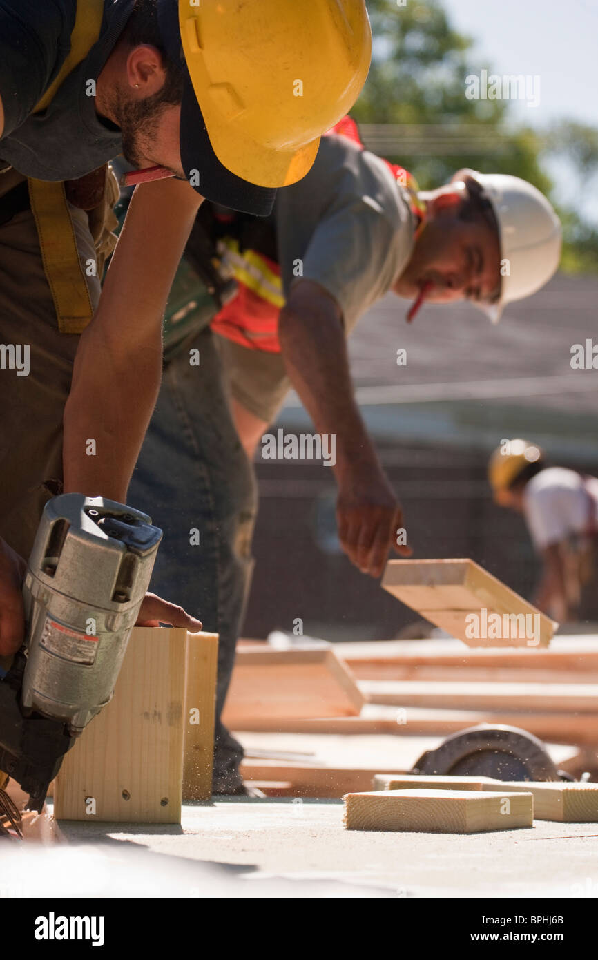 Carpenters working with nail gun and wood Stock Photo - Alamy