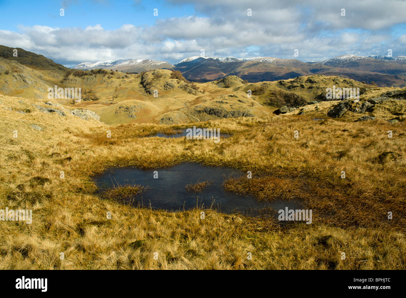 The Helvellyn range from a small tarn on Wetherlam, Coniston Fells ...
