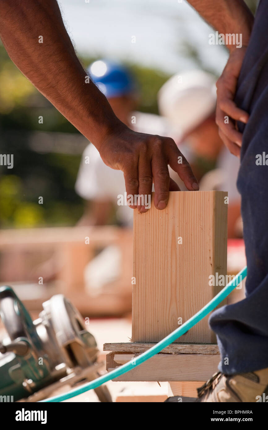 Carpenters positioning wood trim at a construction site Stock Photo - Alamy