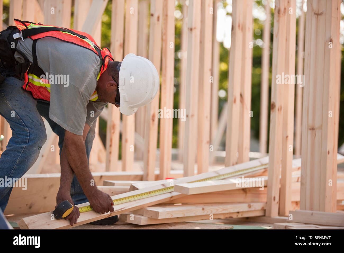 Carpenter measuring wood for framing Stock Photo - Alamy